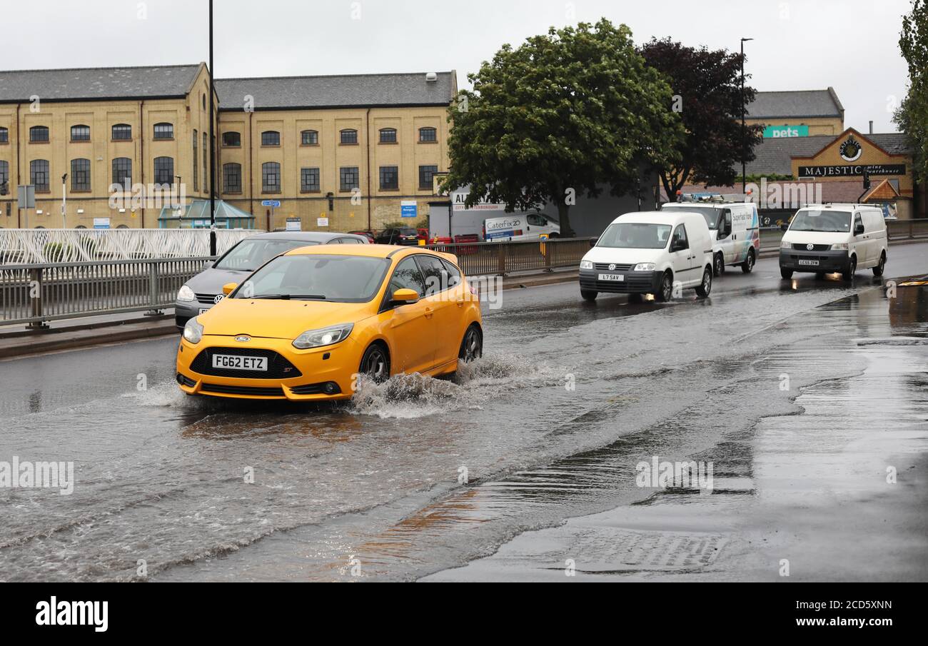 Peterborough, UK. 25th Aug, 2020. Cars battle through a semi-flooded ...