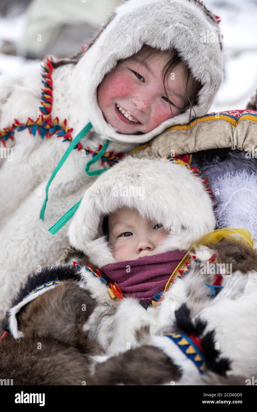 A Nenet young girl and a child on a winter cradle in the Far North ...
