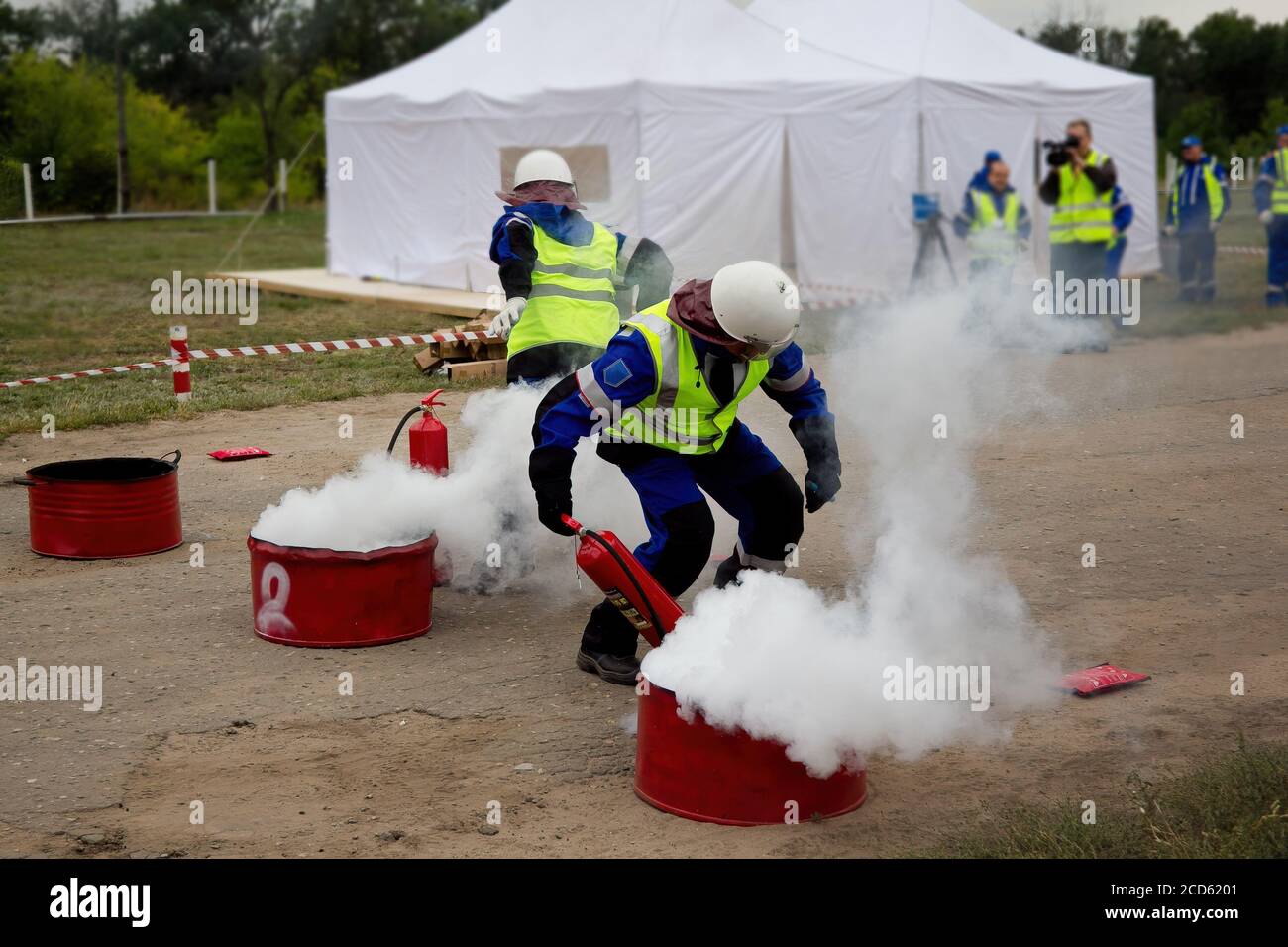 Firefighters on training. Firemen using use a fire extinguisher on a ...