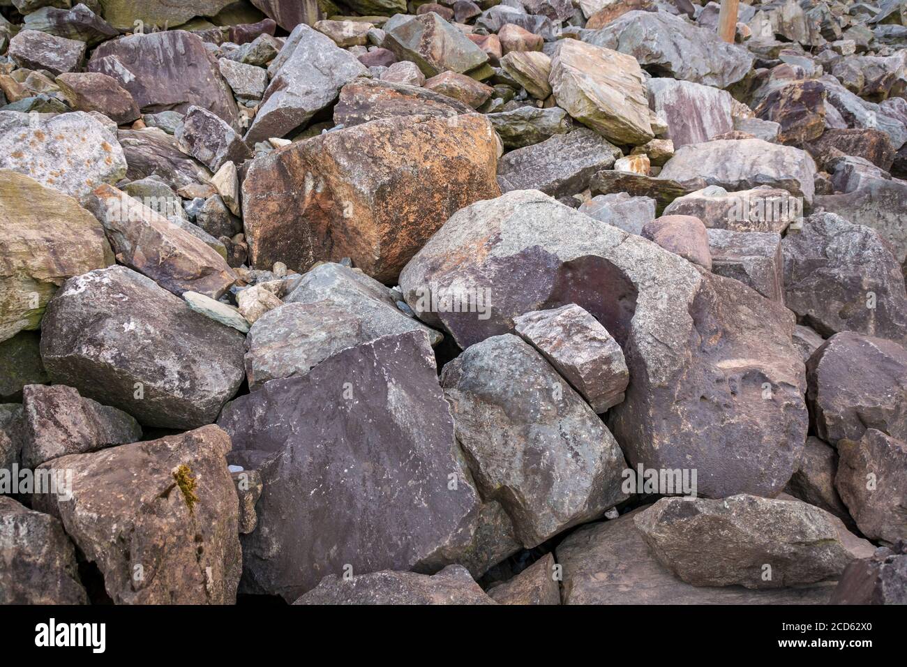 Heavy rocks and boulders of different shades of greys and browns lay ...