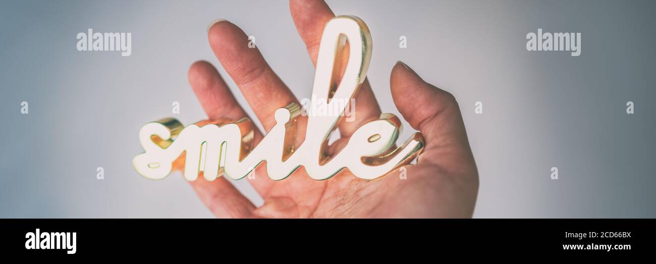 Hand holding smile sign written in metal gold. Text decoration for home ...