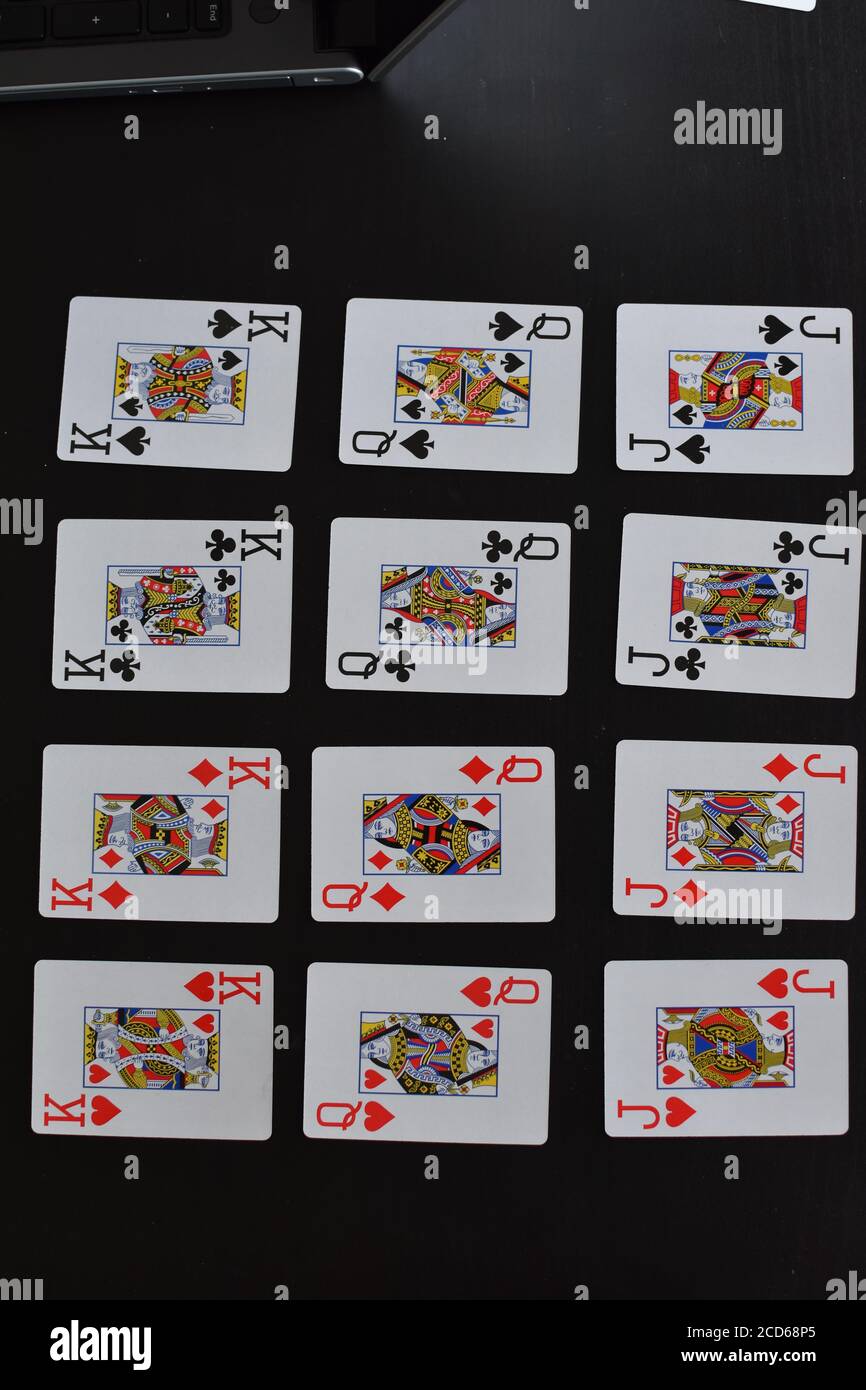 Playing cards arranged on black background Stock Photo - Alamy