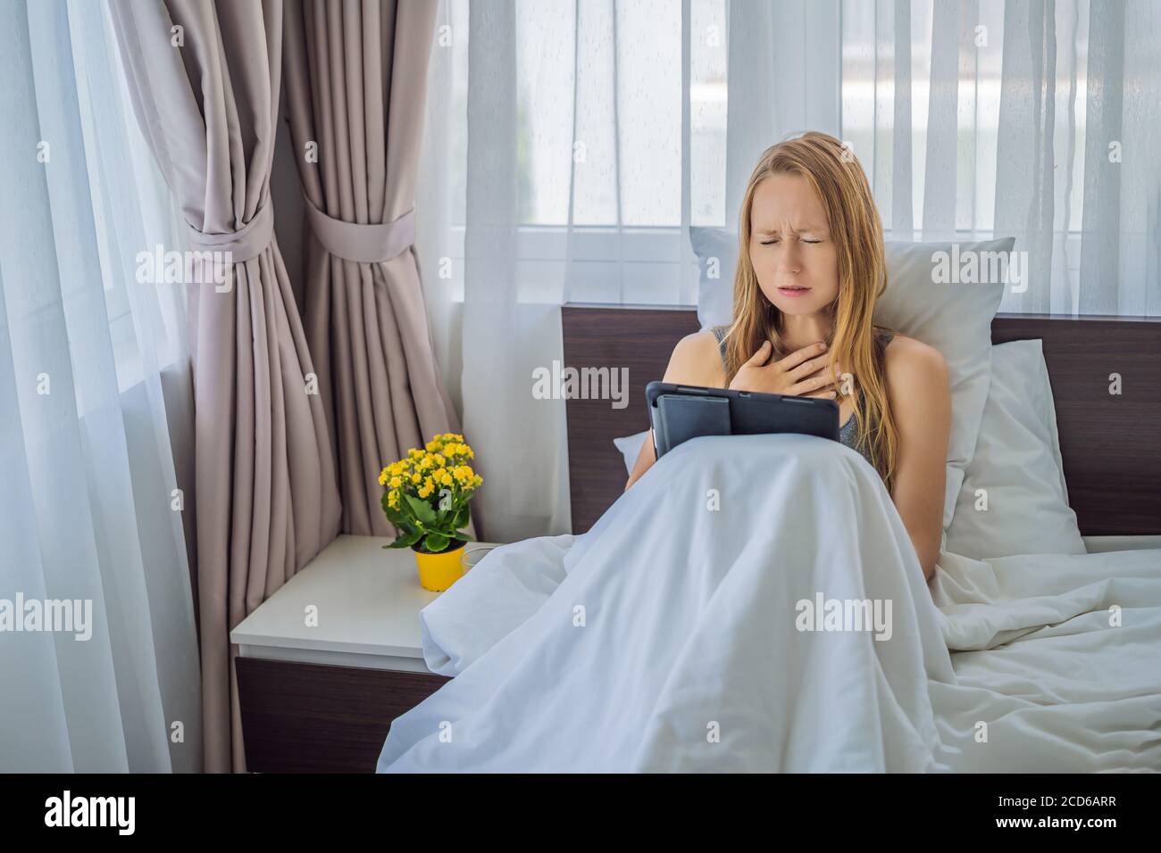 Woman talking by video call while lying in bed Stock Photo - Alamy