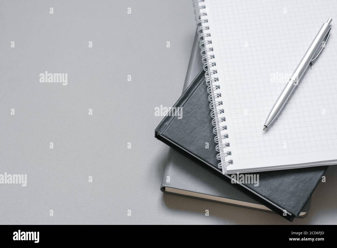 Stylish workplace. Notebooks and diaries on a gray desktop with a pen ...