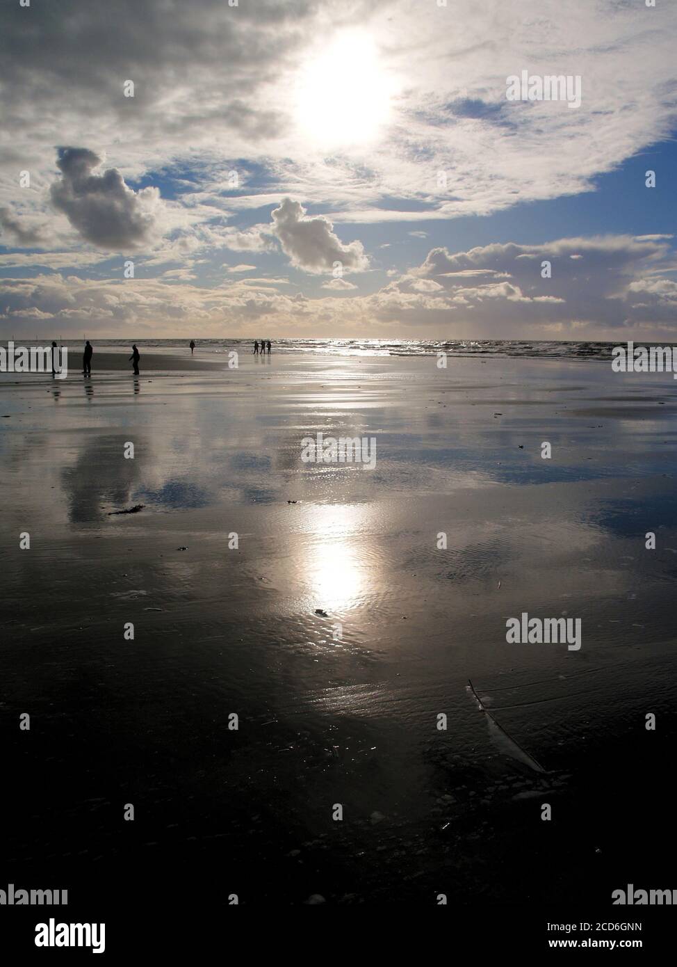 Stunning vertical shot of beautiful cloudscape reflecting on the beach ...