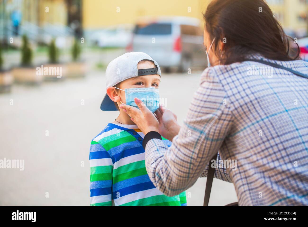 Mother puts on her son sterile medical mask. Mother, child wear ...