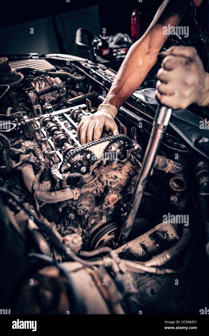 Mechanic working in a car under the hood, repairing an engine Stock ...