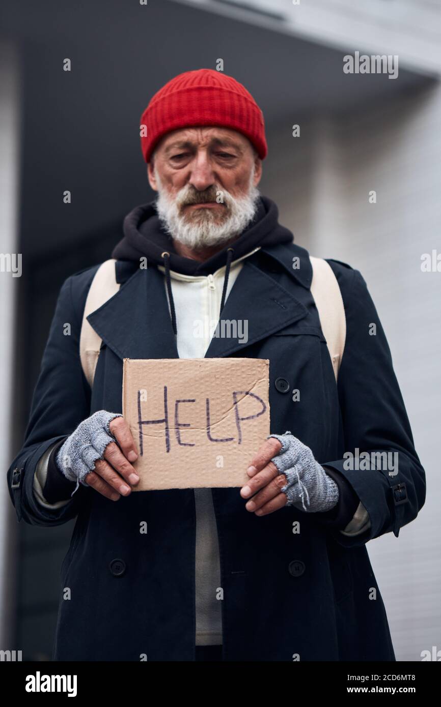 Old grey bearded man standing with sign HELP, asking for money, food ...