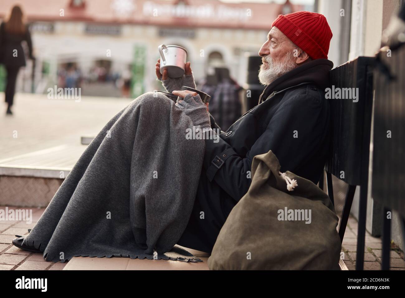 Beggar male sit with jar for money, wearing warm old clothes. Vagrant ...