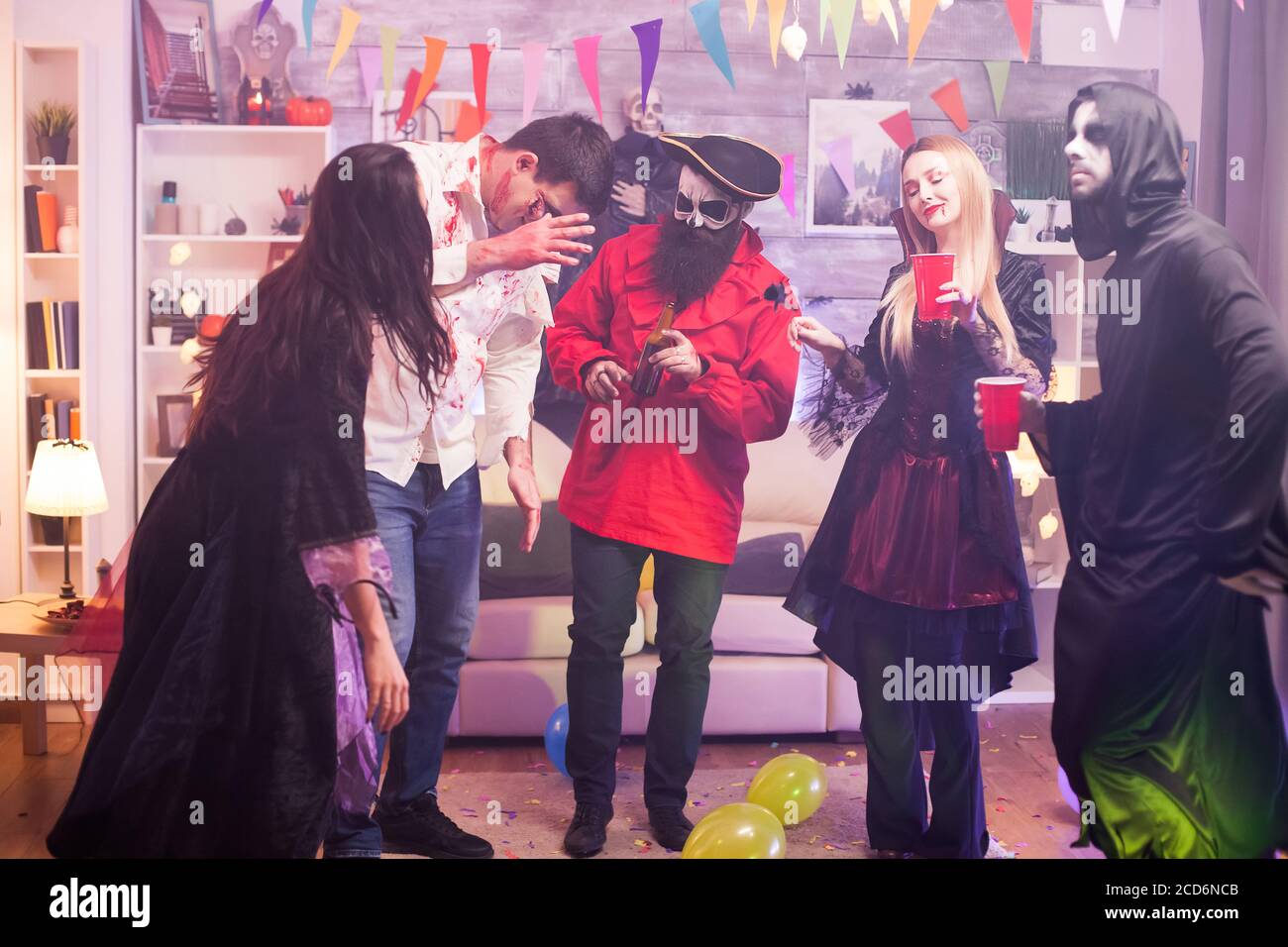 Group of friends celebrating halloween dressed up like spooky monsters ...