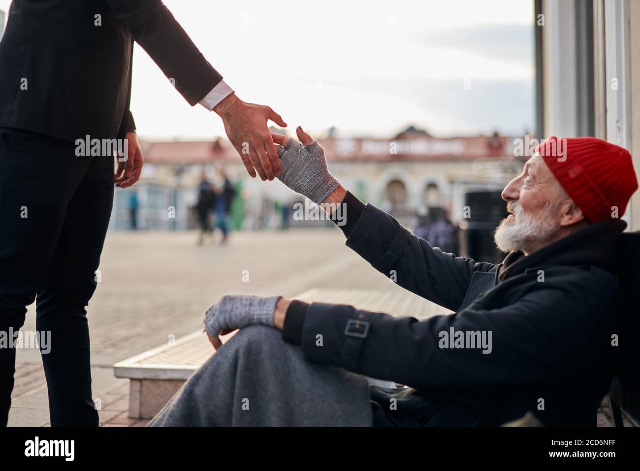 Senior beggar sitting beside street with request help with receive some ...
