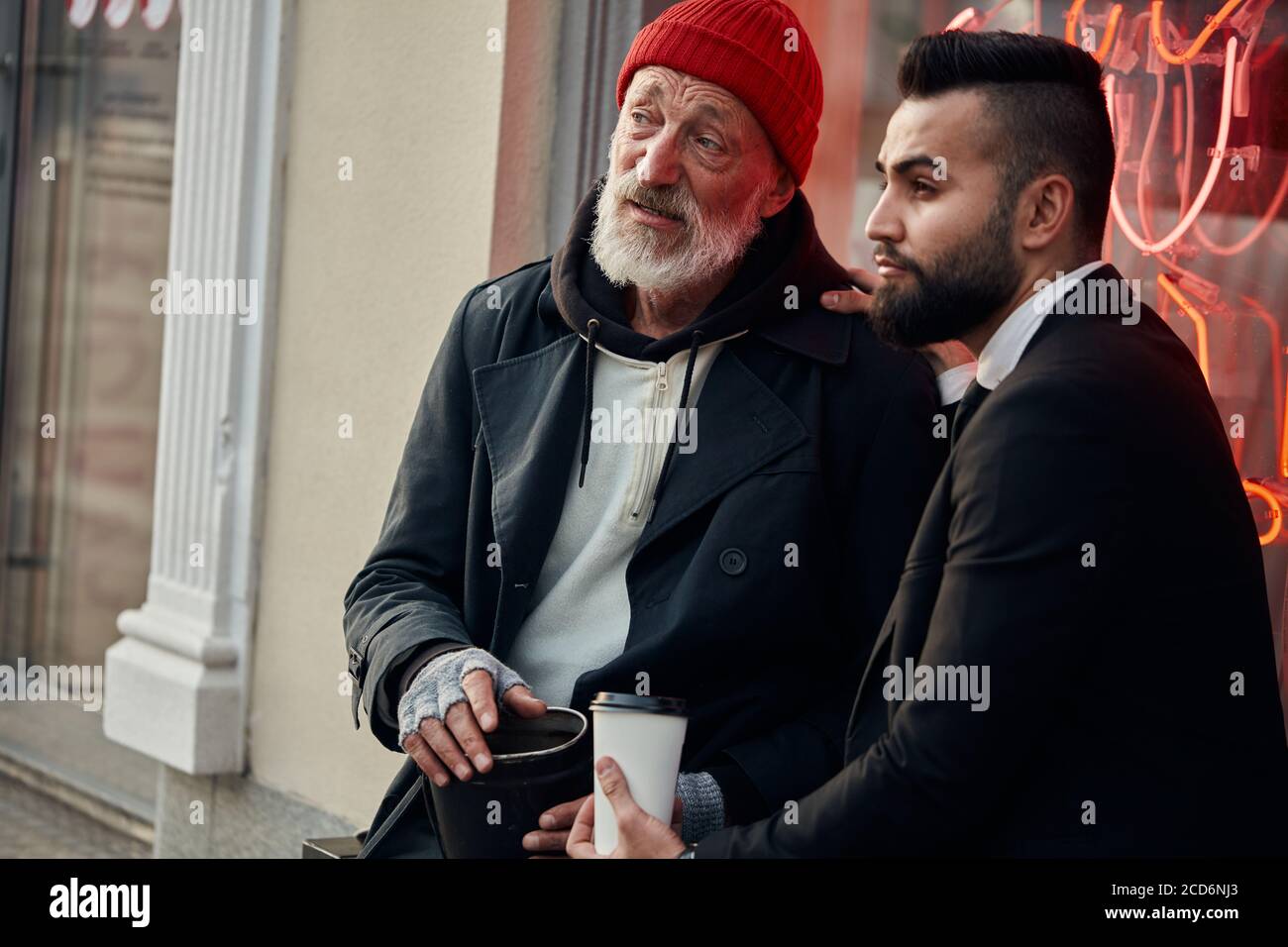 Rich man in tuxedo and homeless person in dirty clothes sitting and ...
