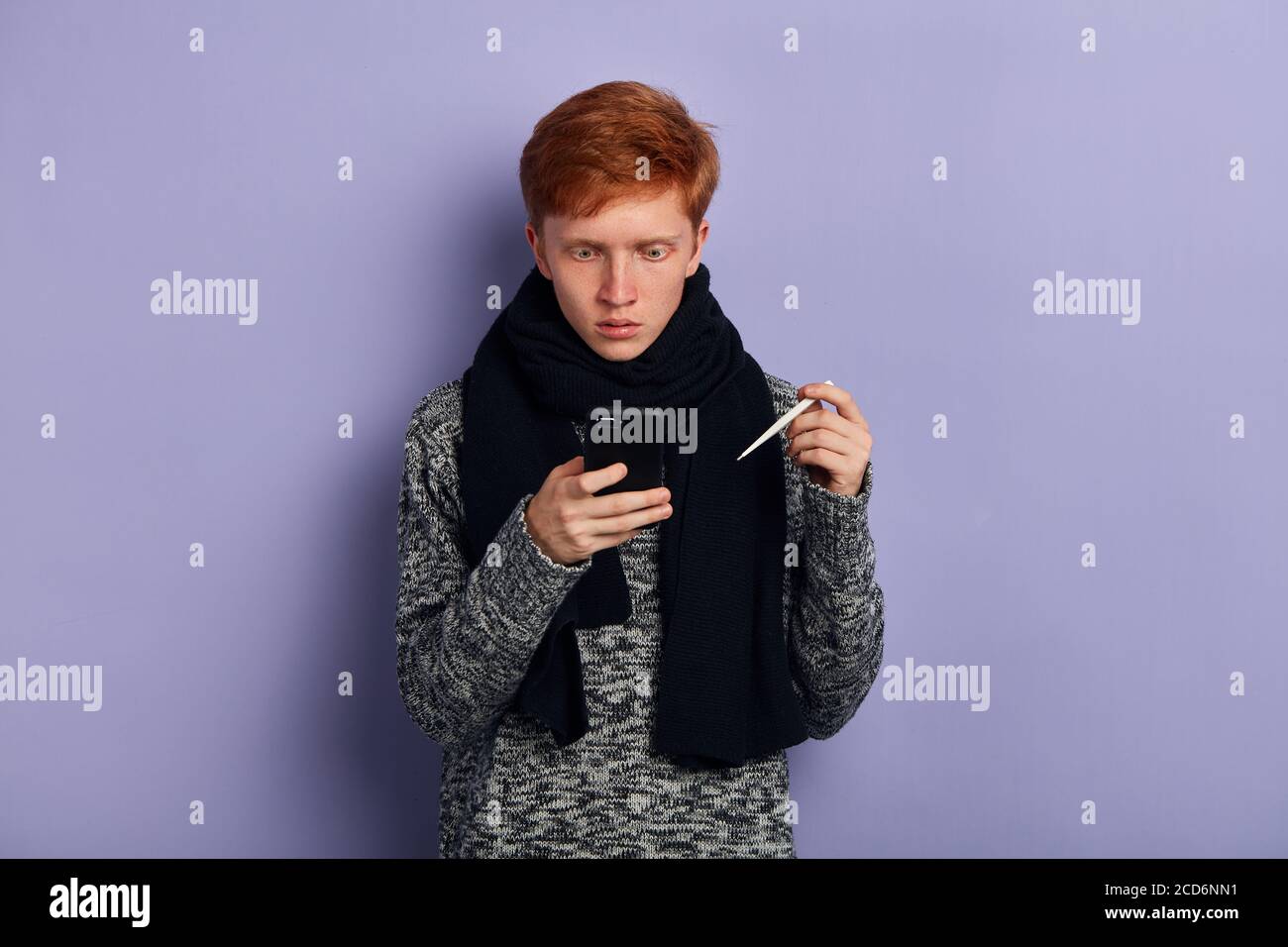 ginger sick weak puzzled man cannot make a phone call,loking at the ...