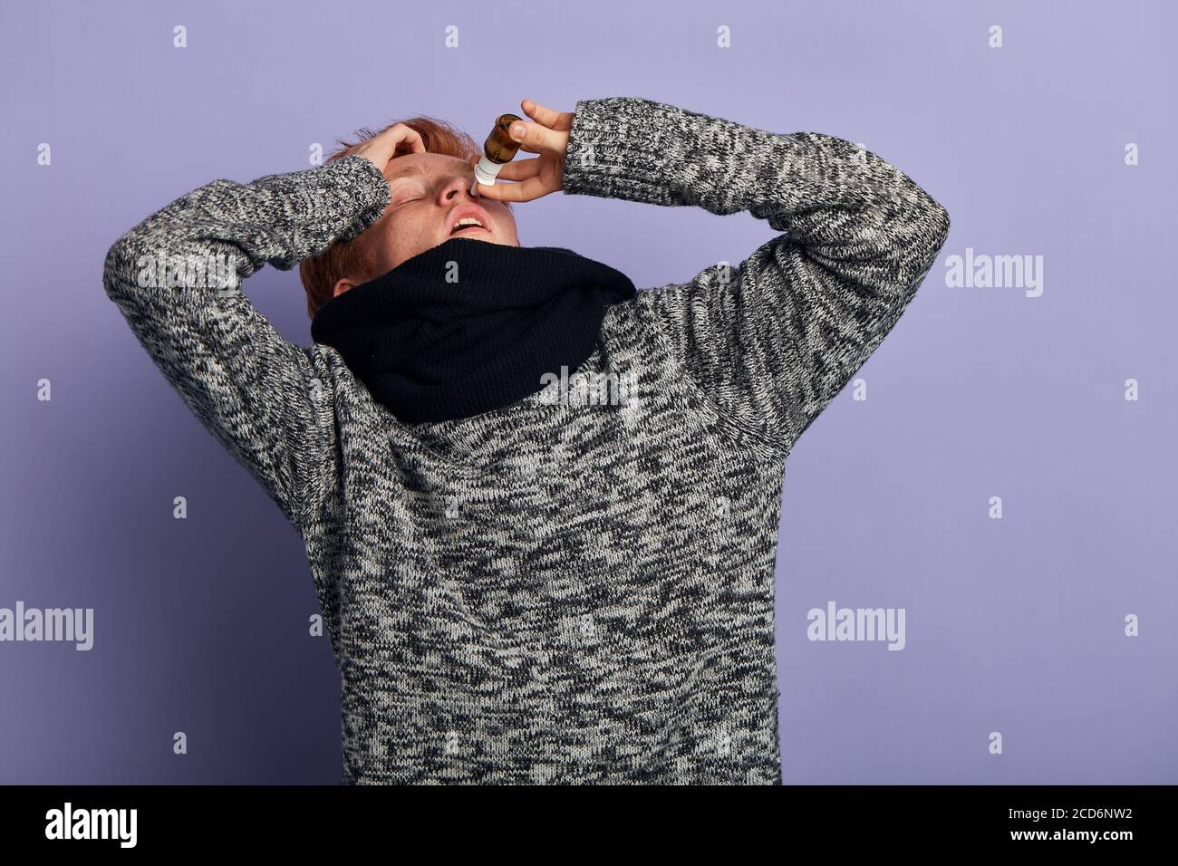 sick man dripping nasal drops. close up portrait, isolated blue ...