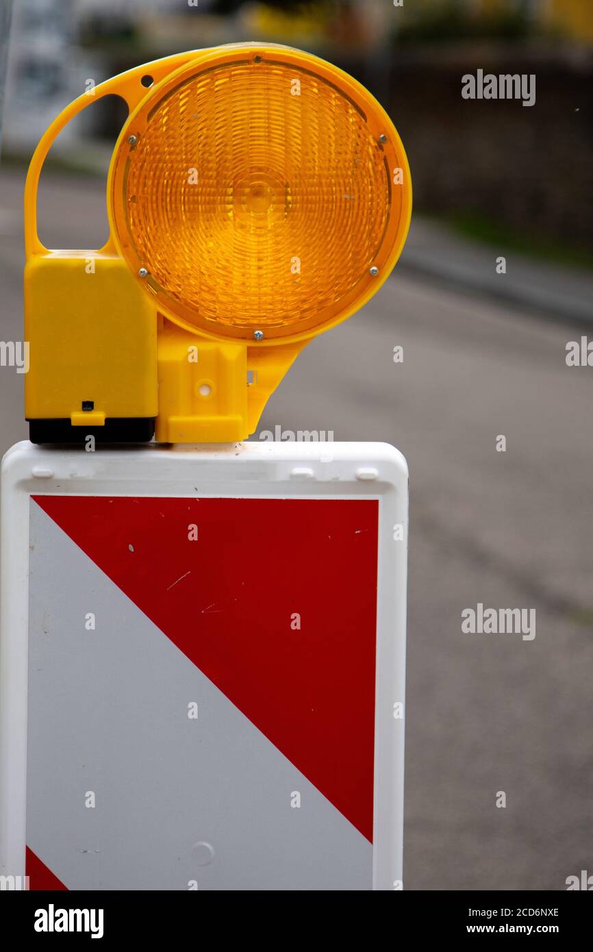Close-up of a yellow warning light with a street barrier Stock Photo ...