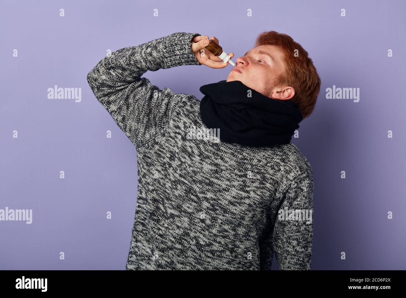 young man has cought cold in winter. close up portrait, isolated blue ...