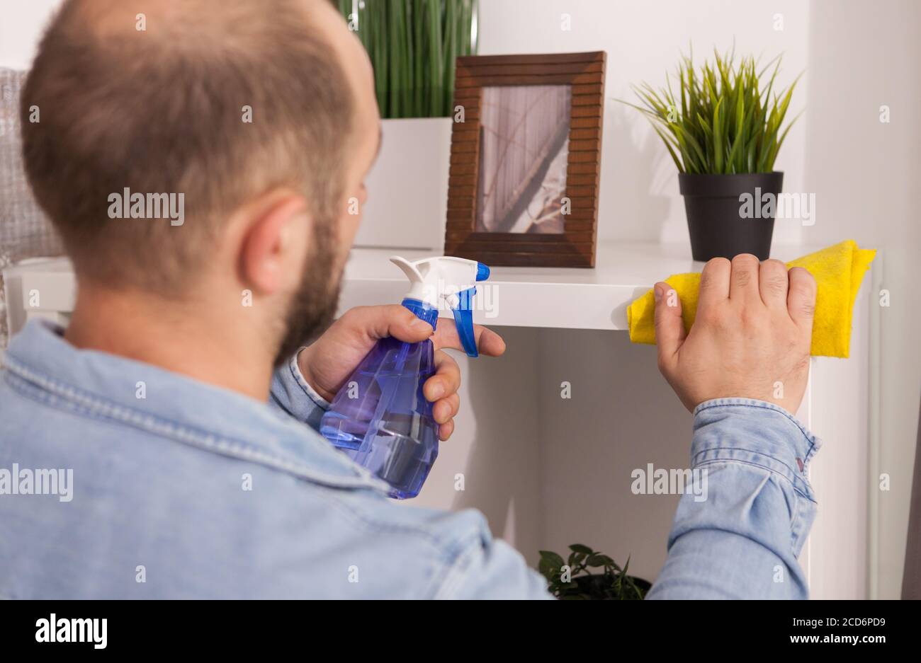 Man cleans up dust keeping his house clean Stock Photo - Alamy