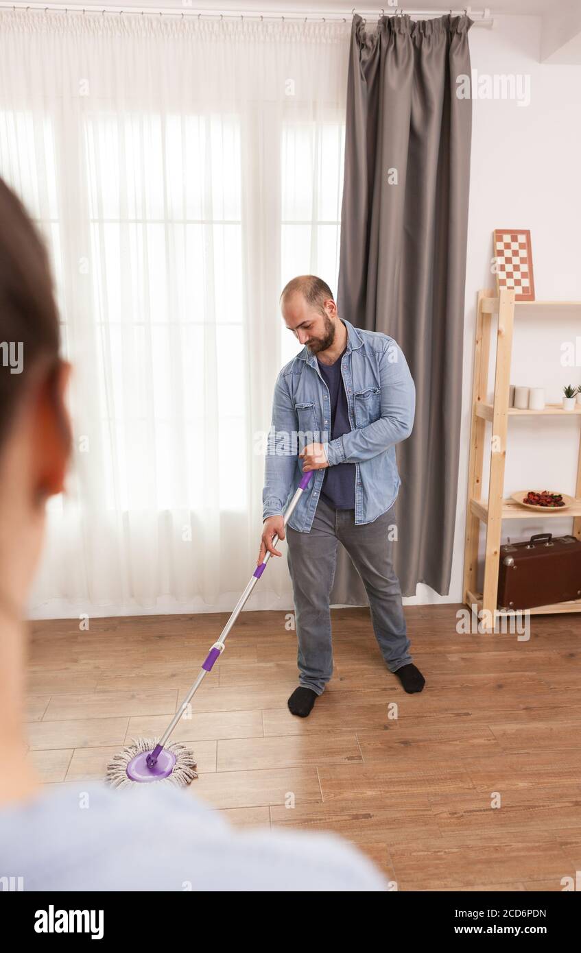 Boyfriend mopping the floor in living room Stock Photo - Alamy