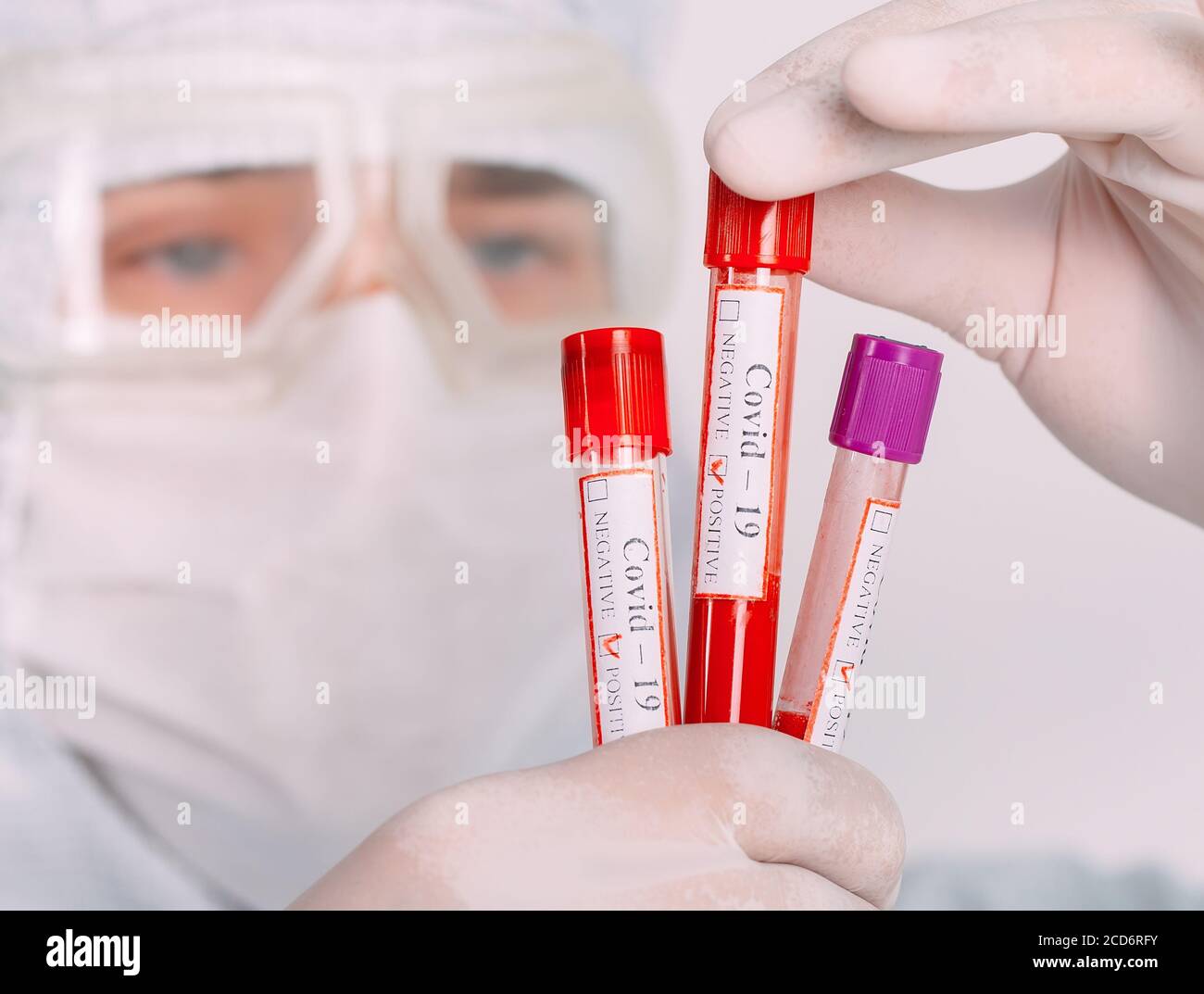doctor man in flu mask and protective gloves holding a test tube with a ...