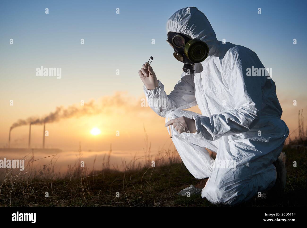 Crouched researcher working outdoors on the hill collecting samples for ...
