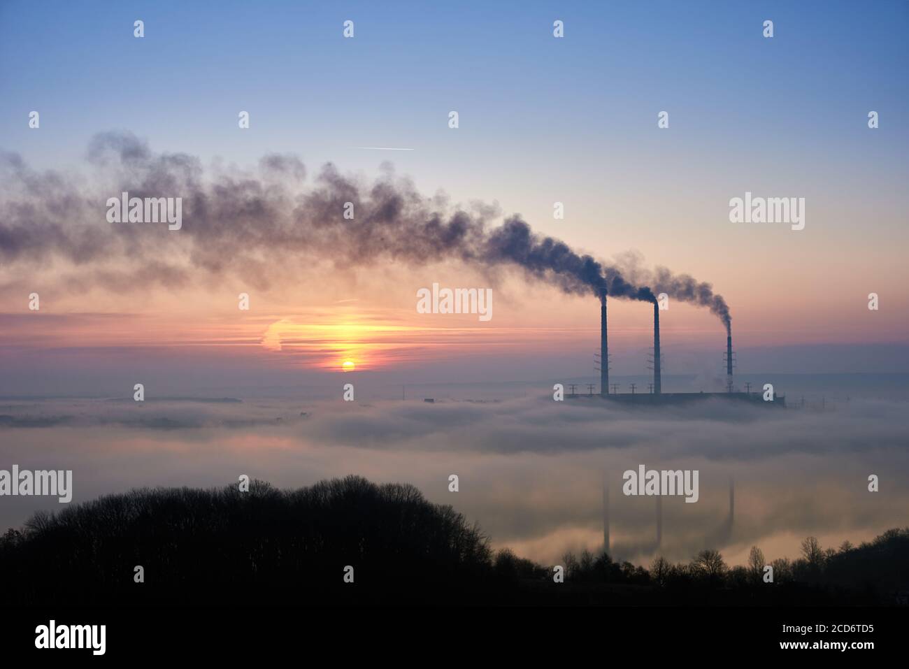 Stunning view of sky with bright rising sun at thermoelectric power ...