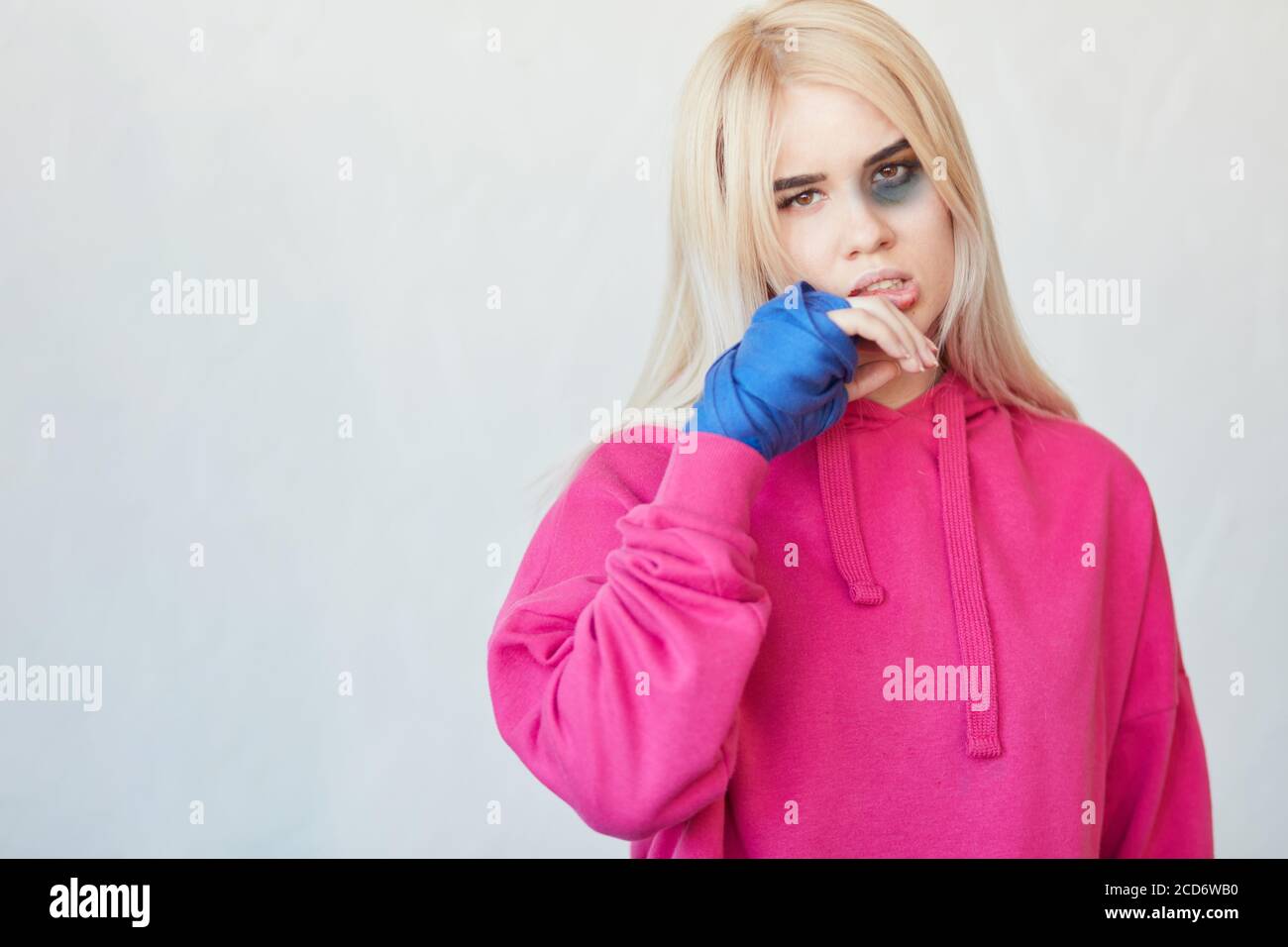 Female kick boxer with long blonde hair dressed in pink hoodie and ...