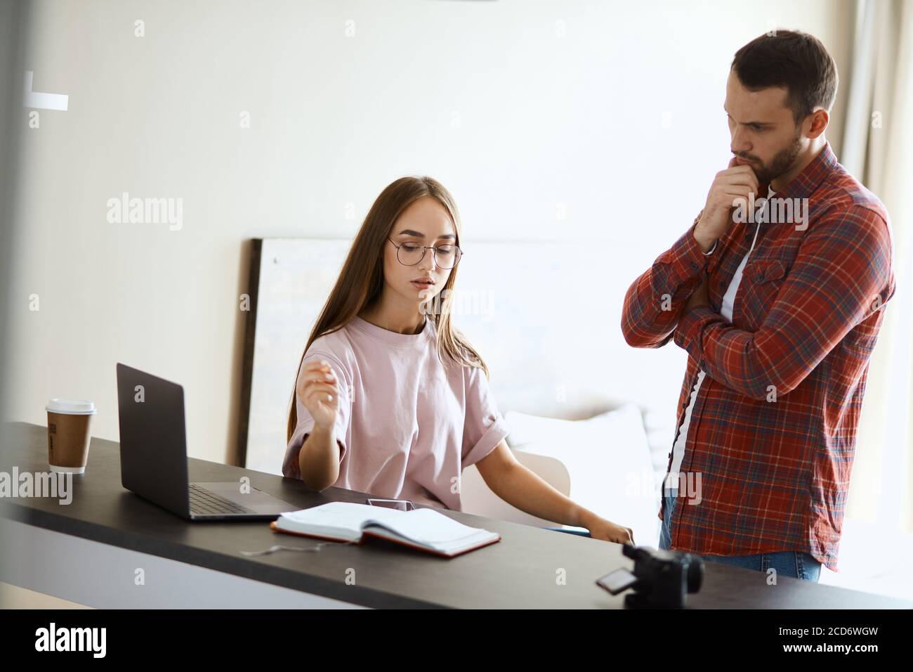 Portrait of young couple discussing family issues, looking at screen ...