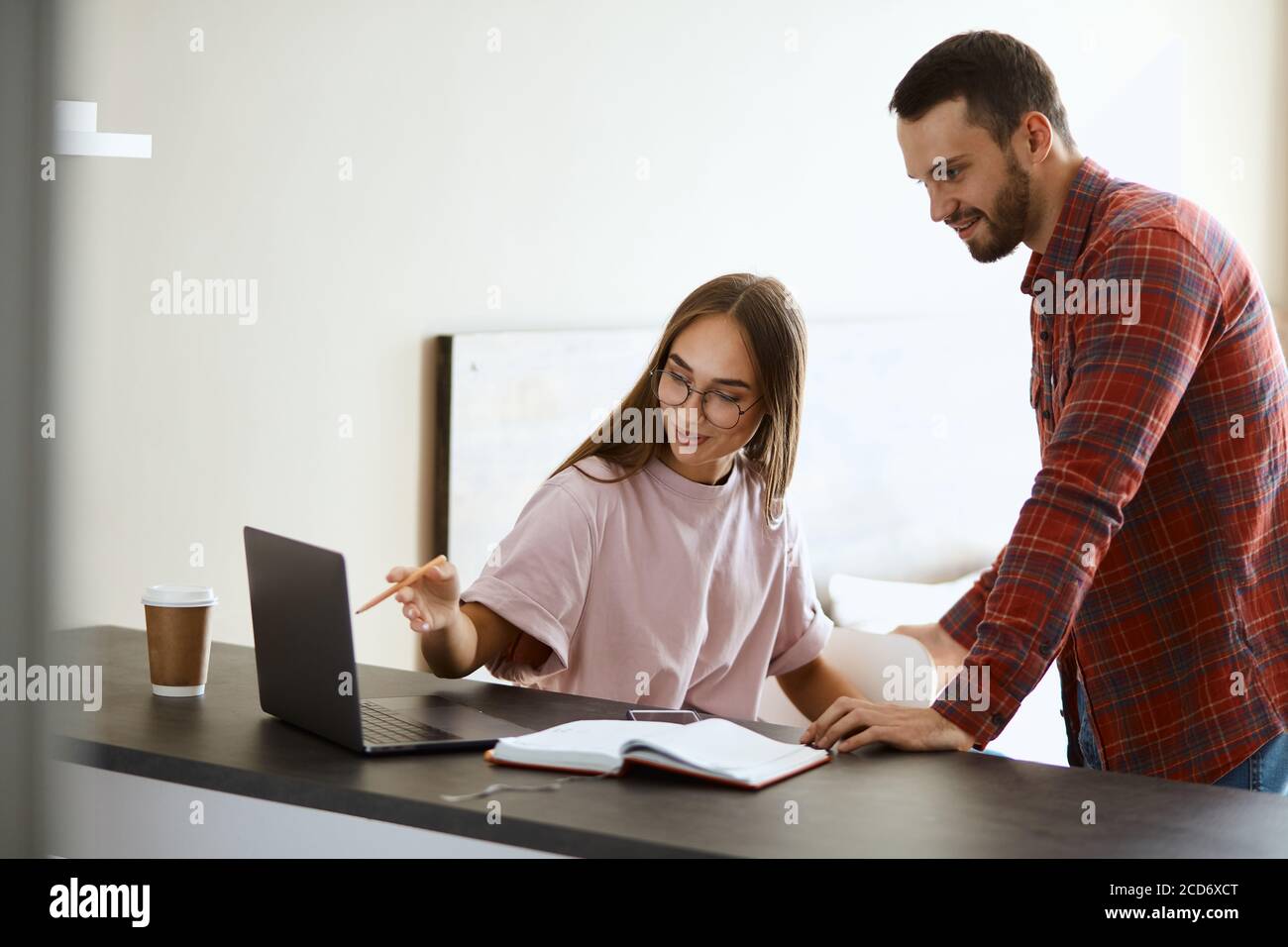 charming playful girlfriend points at screen of laptop computer ...
