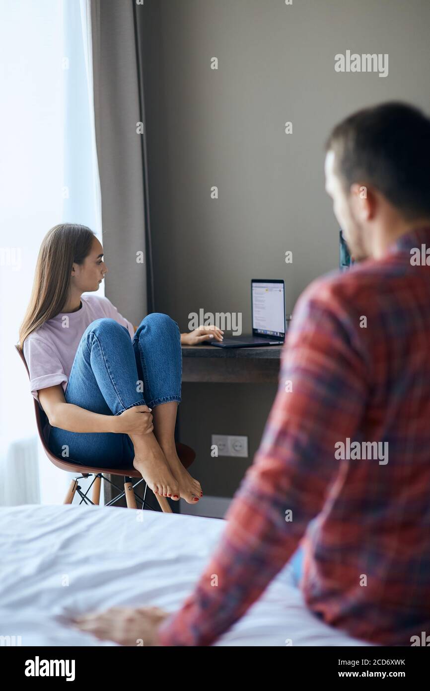 Pretty charming woman sitting in chair in front of laptop computer ...