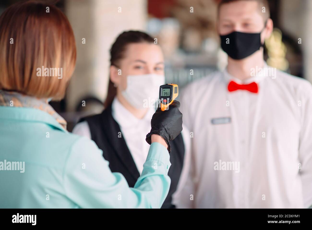 The Manager of a restaurant or hotel checks the body temperature of the ...