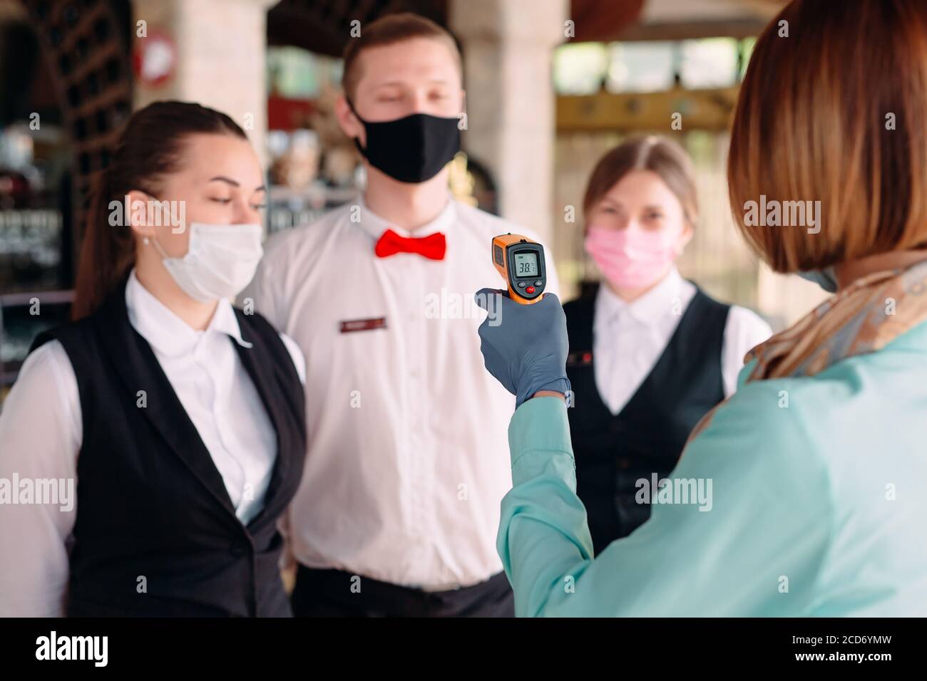The Manager of a restaurant or hotel checks the body temperature of the ...