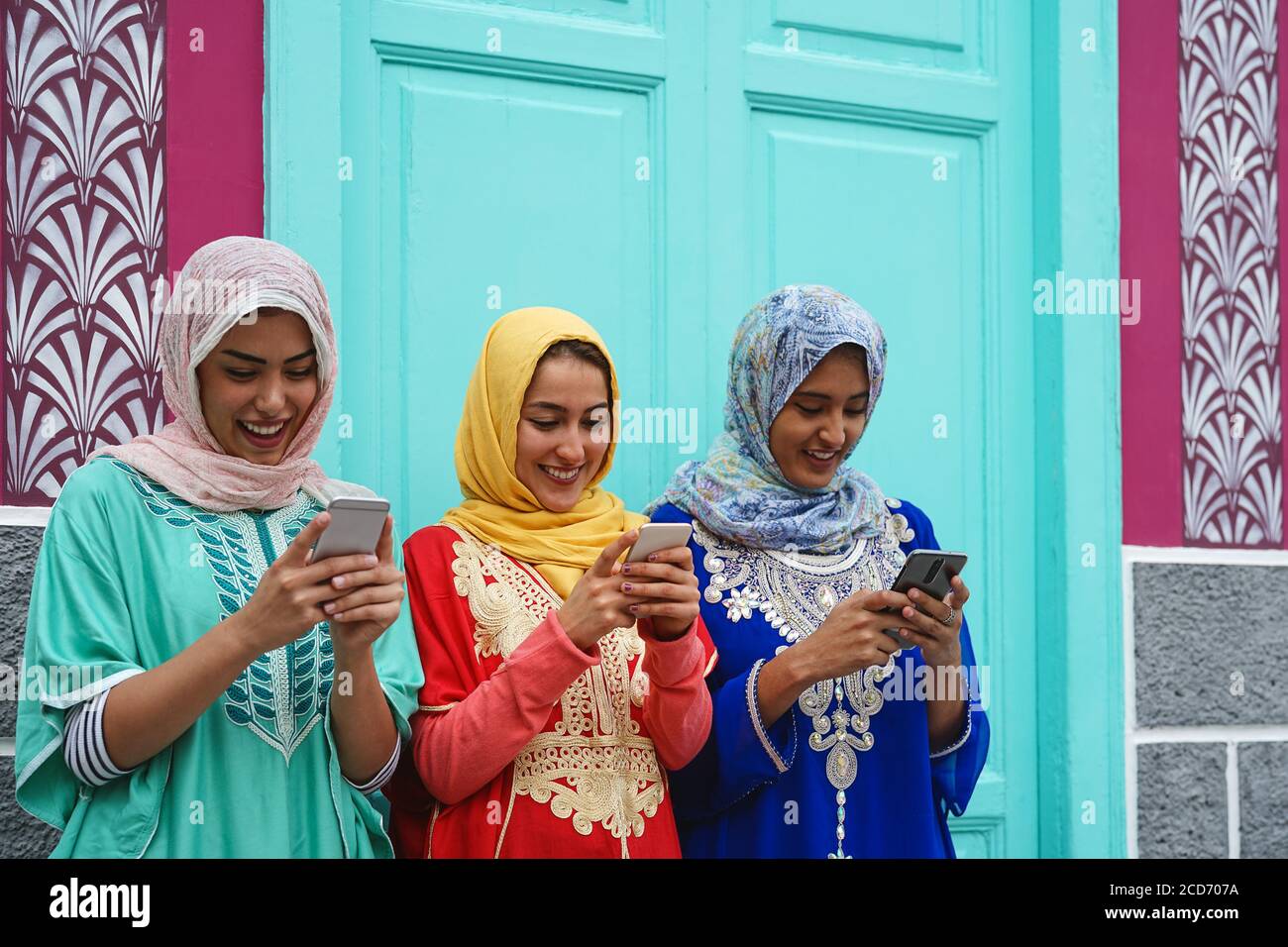 Young Muslim friends using mobile smartphones outdoor - Happy Arabian ...