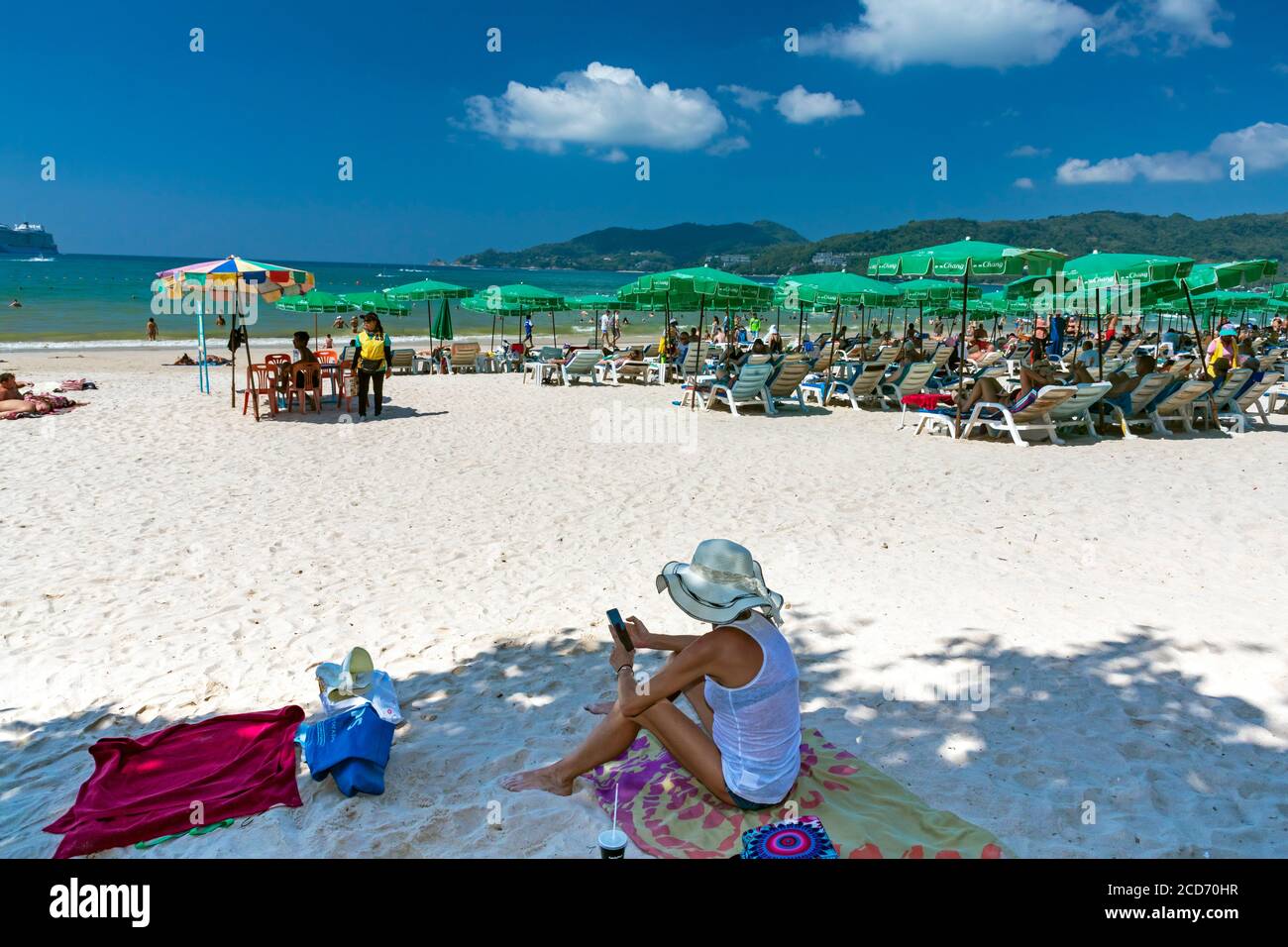Tourist Using Mobile Phone In The Shade On The Beach Patong Phuket