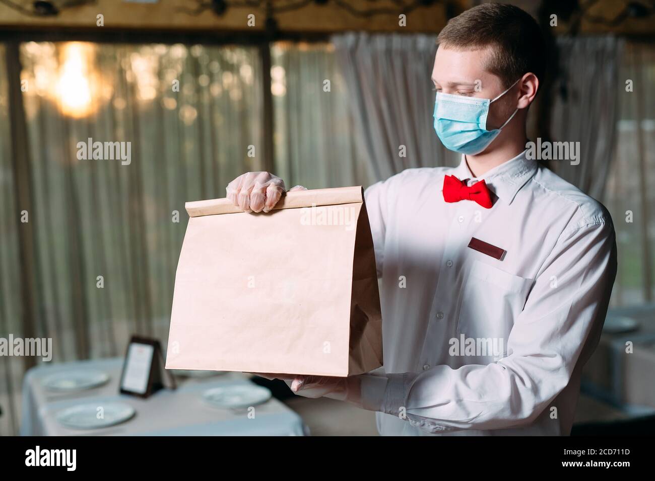 Food delivery from the restaurant. Portrait of a waiter holding a craft ...