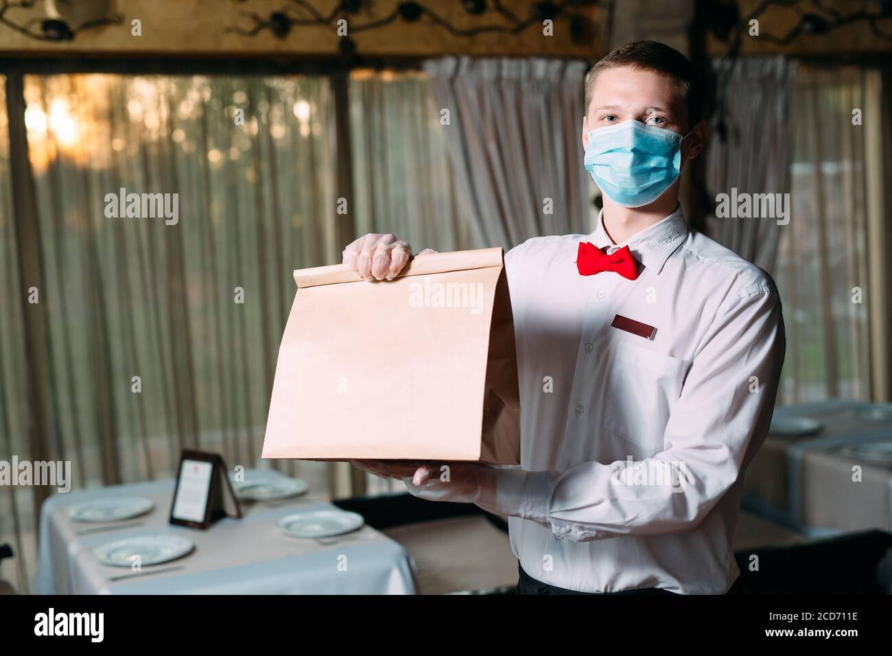 Food delivery from the restaurant. Portrait of a waiter holding a craft ...