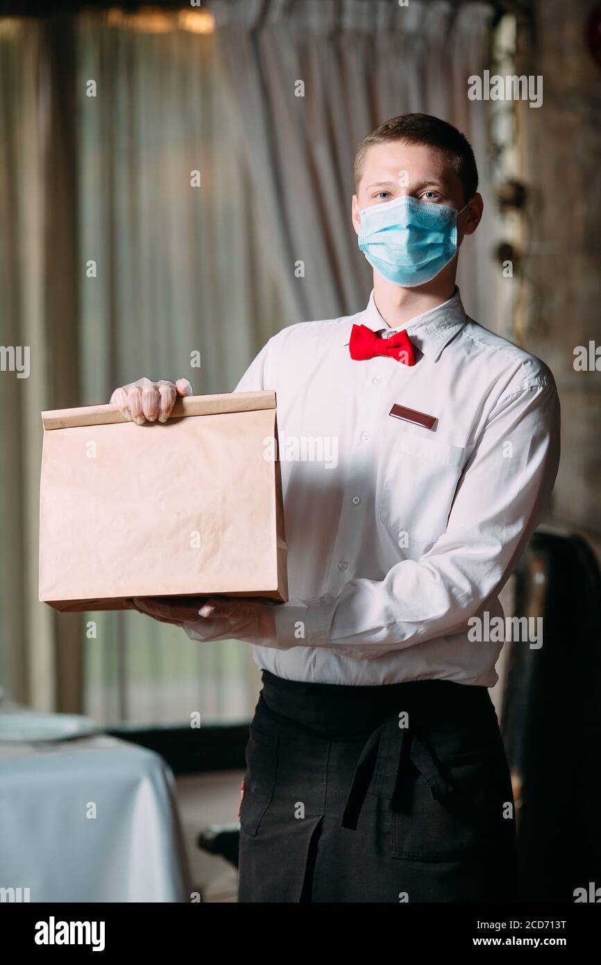 Food delivery from the restaurant. Portrait of a waiter holding a craft ...