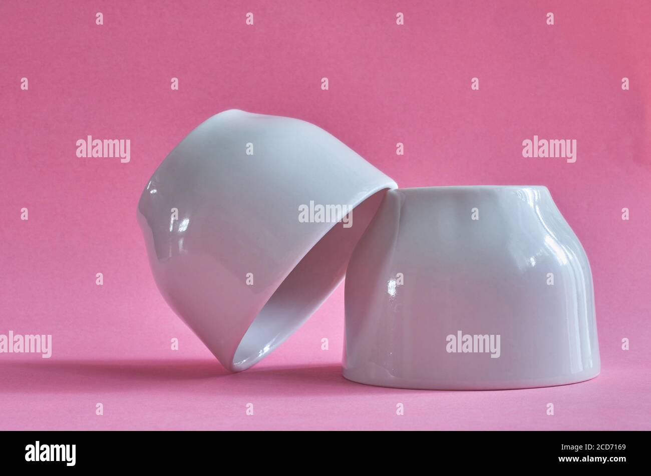 Two white ceramic cups without handles on a pink background Stock Photo ...