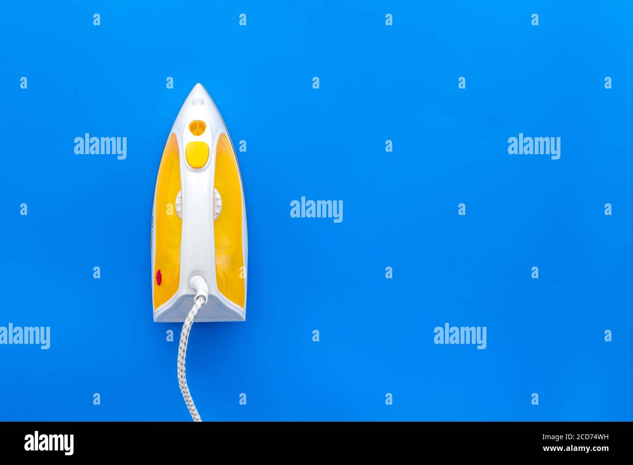 Yellow iron on ironing board. Top view, copy space Stock Photo - Alamy