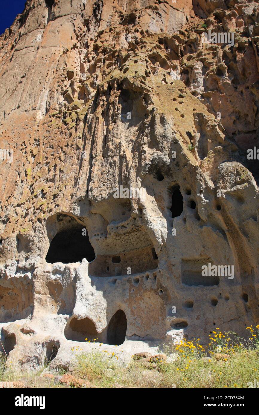Caves or cliff dwellings carved by ancestral Pueblo peoples into pink ...