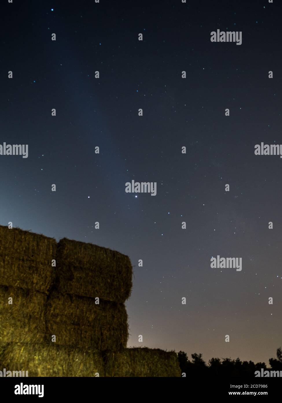Long exposure night scene of isolated square haystacks on a rural farm ...