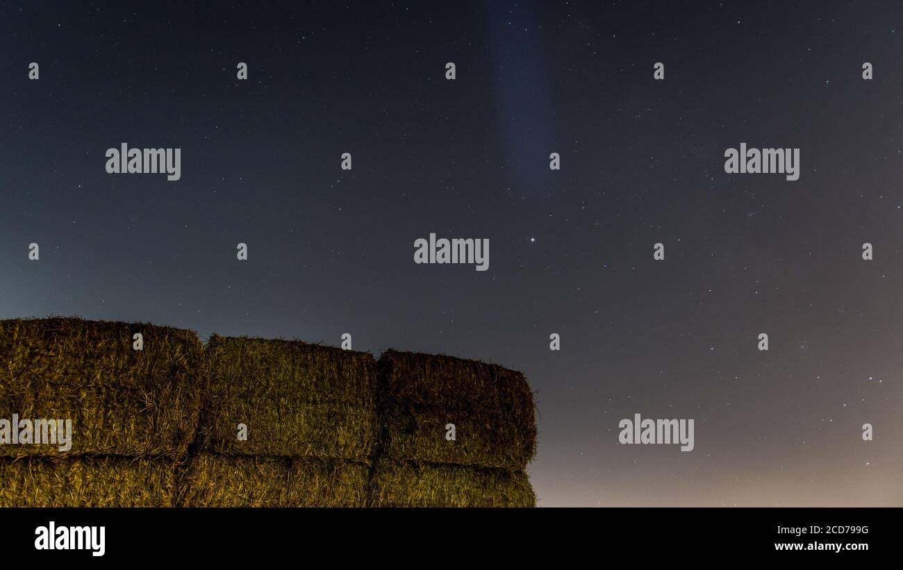 Long exposure night scene of isolated square haystacks on a rural farm ...