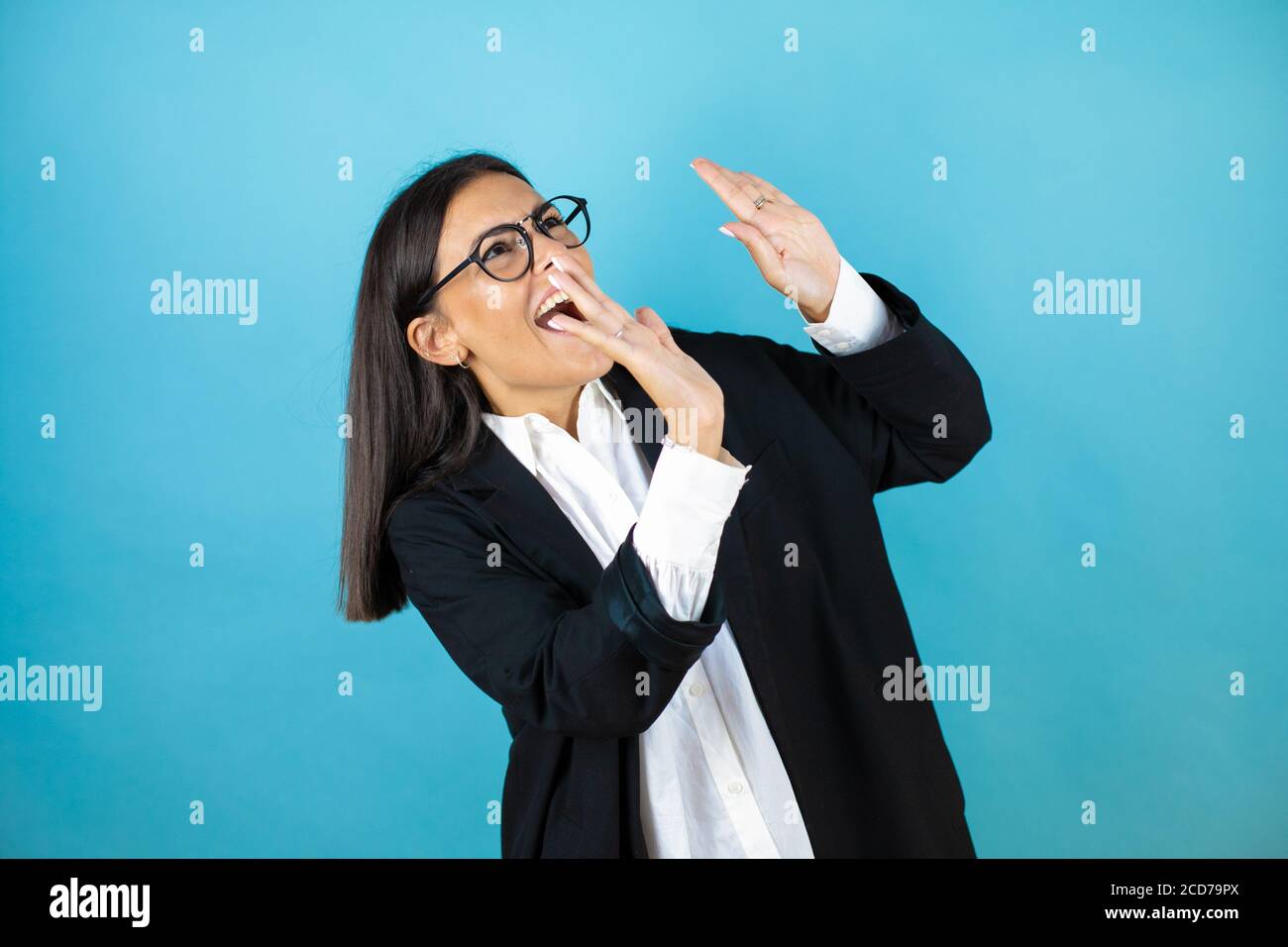 Young beautiful business woman over isolated blue background scared ...