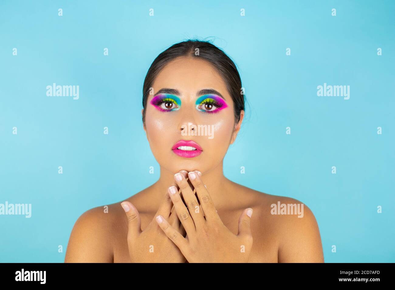 Beauty portrait of female model with vivid makeup on blue background ...