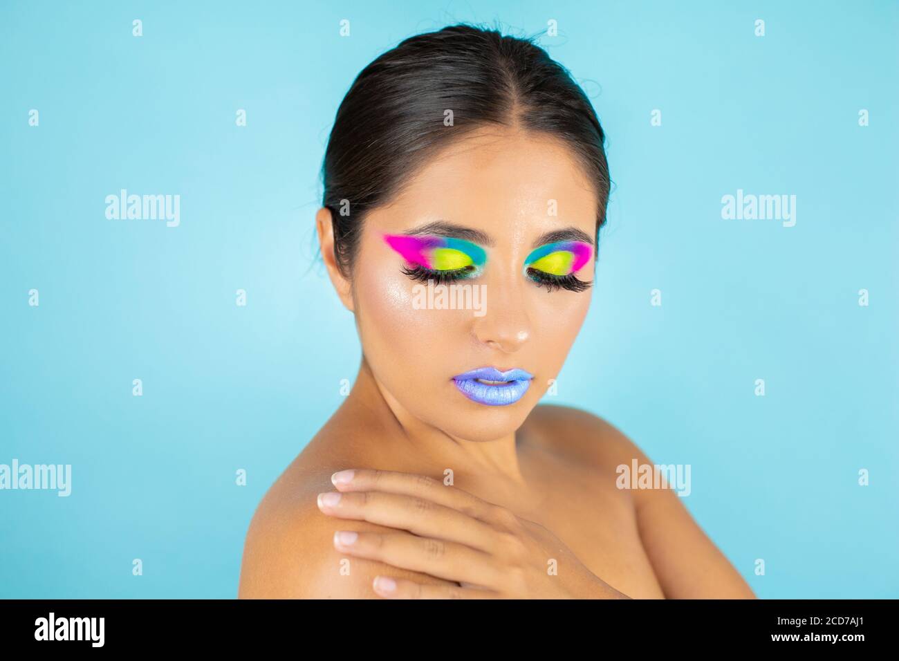 Beauty portrait of female model with vivid makeup on blue background ...
