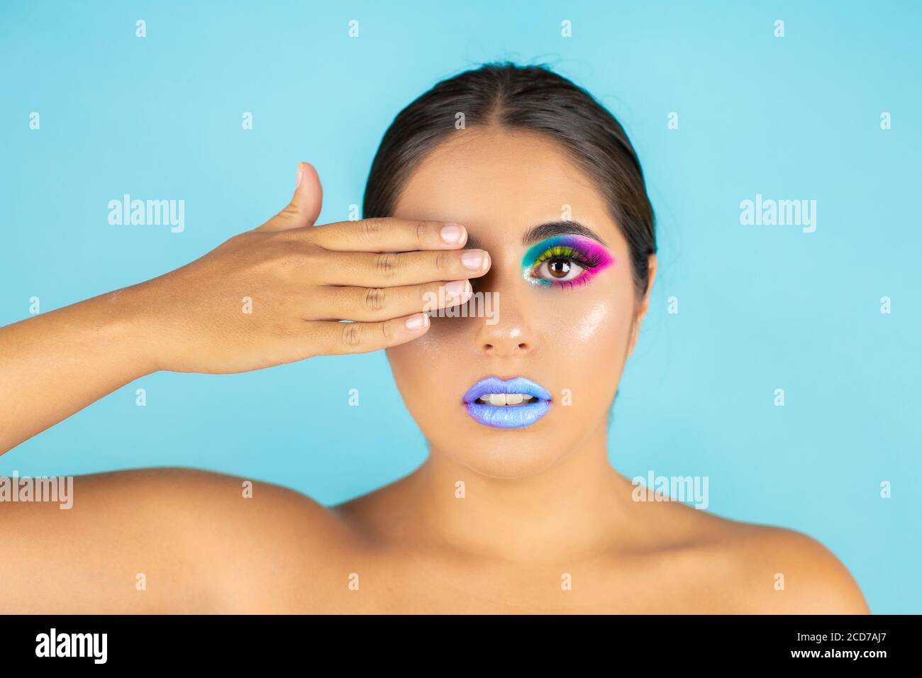 Beauty portrait of female model with vivid makeup on blue background ...