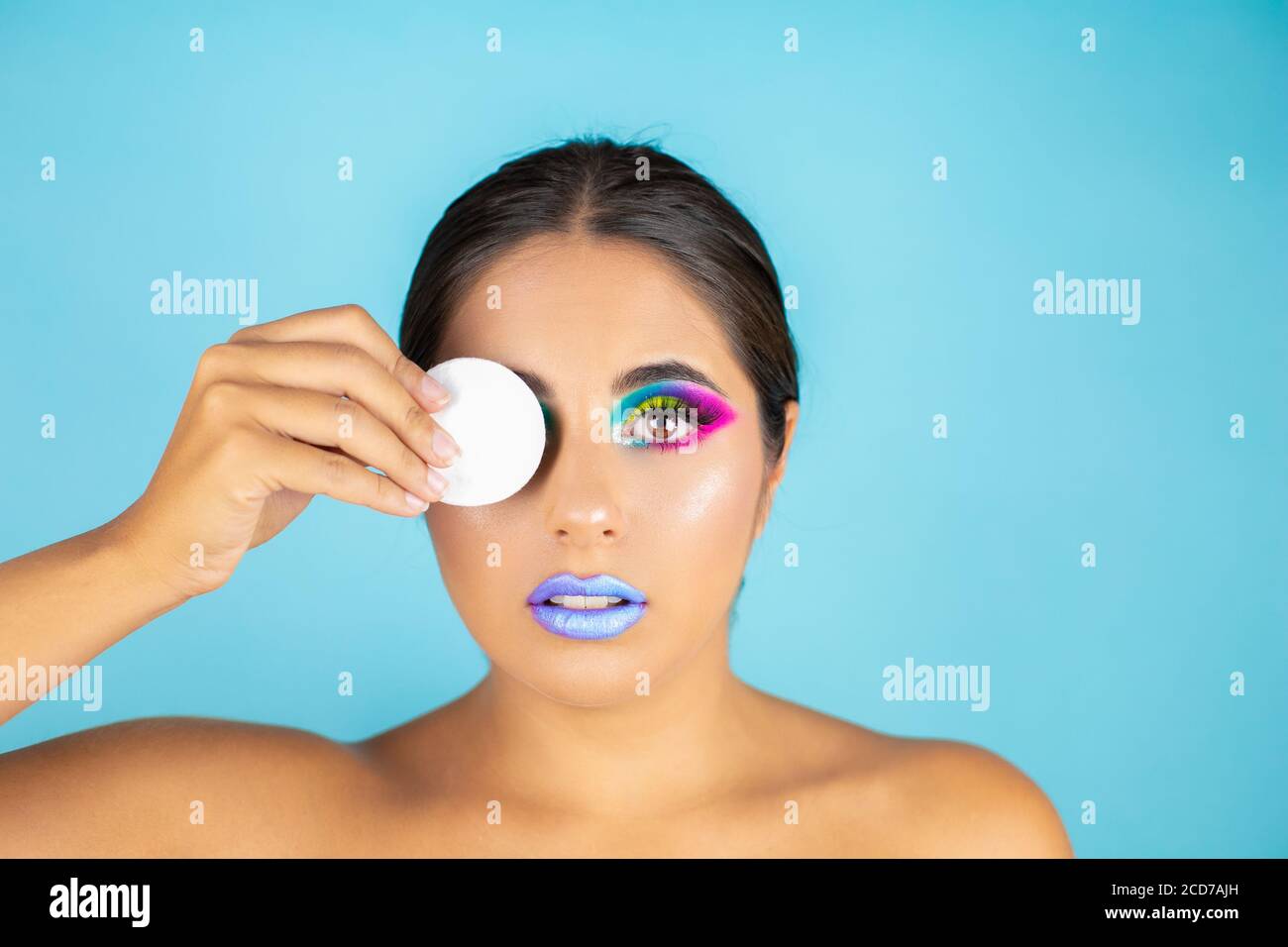 Beauty portrait of female model with vivid makeup and disk on blue ...