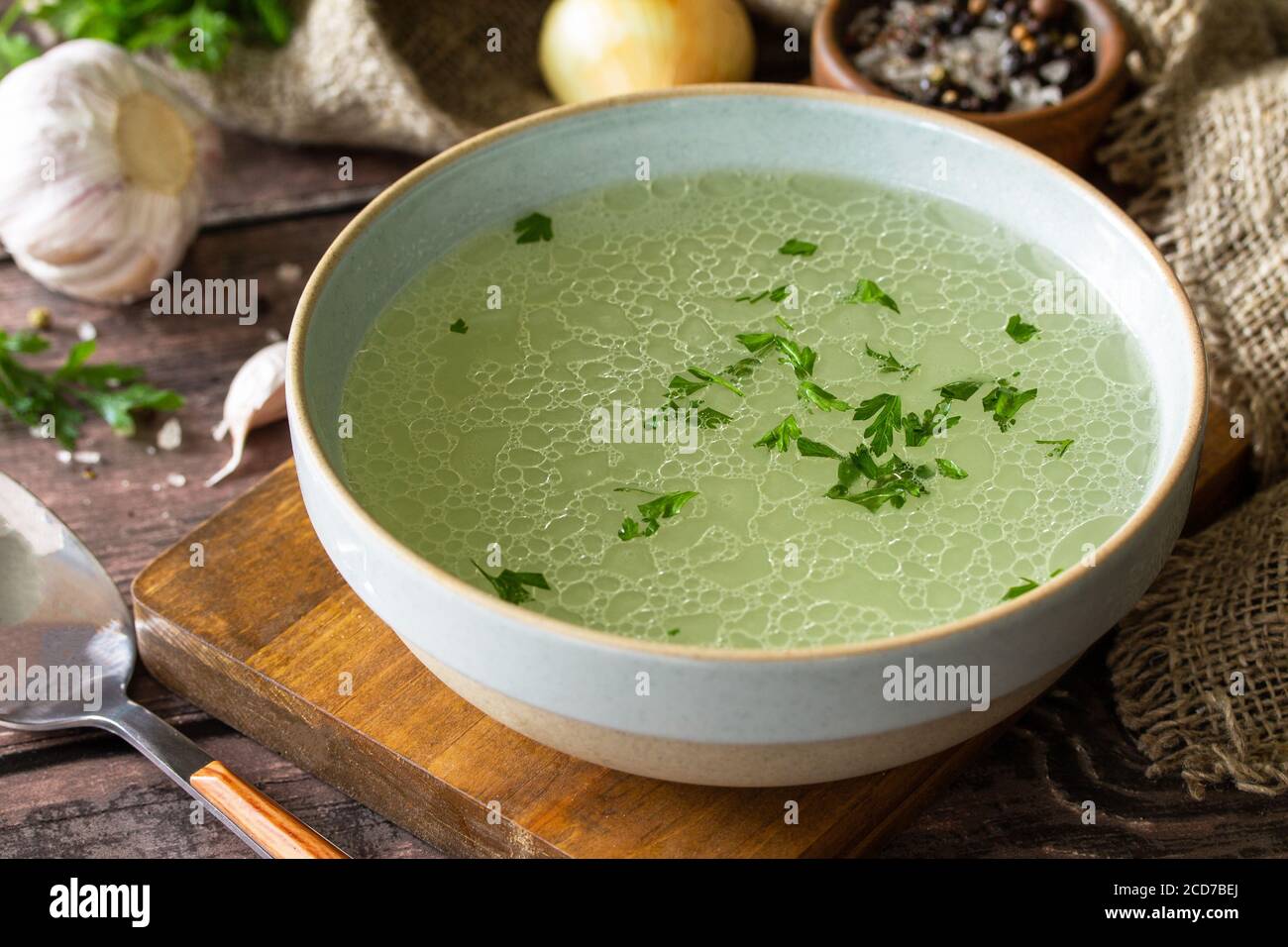 Hot rich meat broth (bouillon) with herbs on a rustic table Stock Photo ...