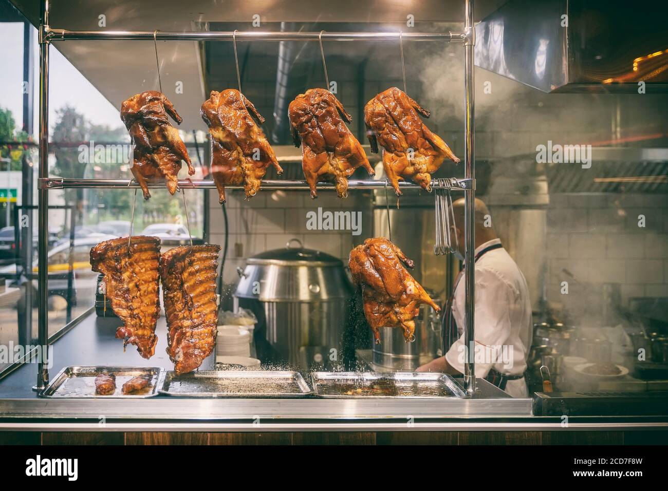 Roasted smoked ducks hanging on rack showcase, restaurant's kitchen ...