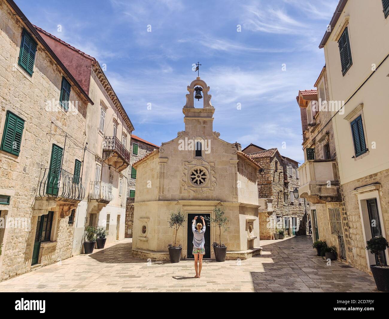 Female tourist taking photo of mall church on square of small urban ...