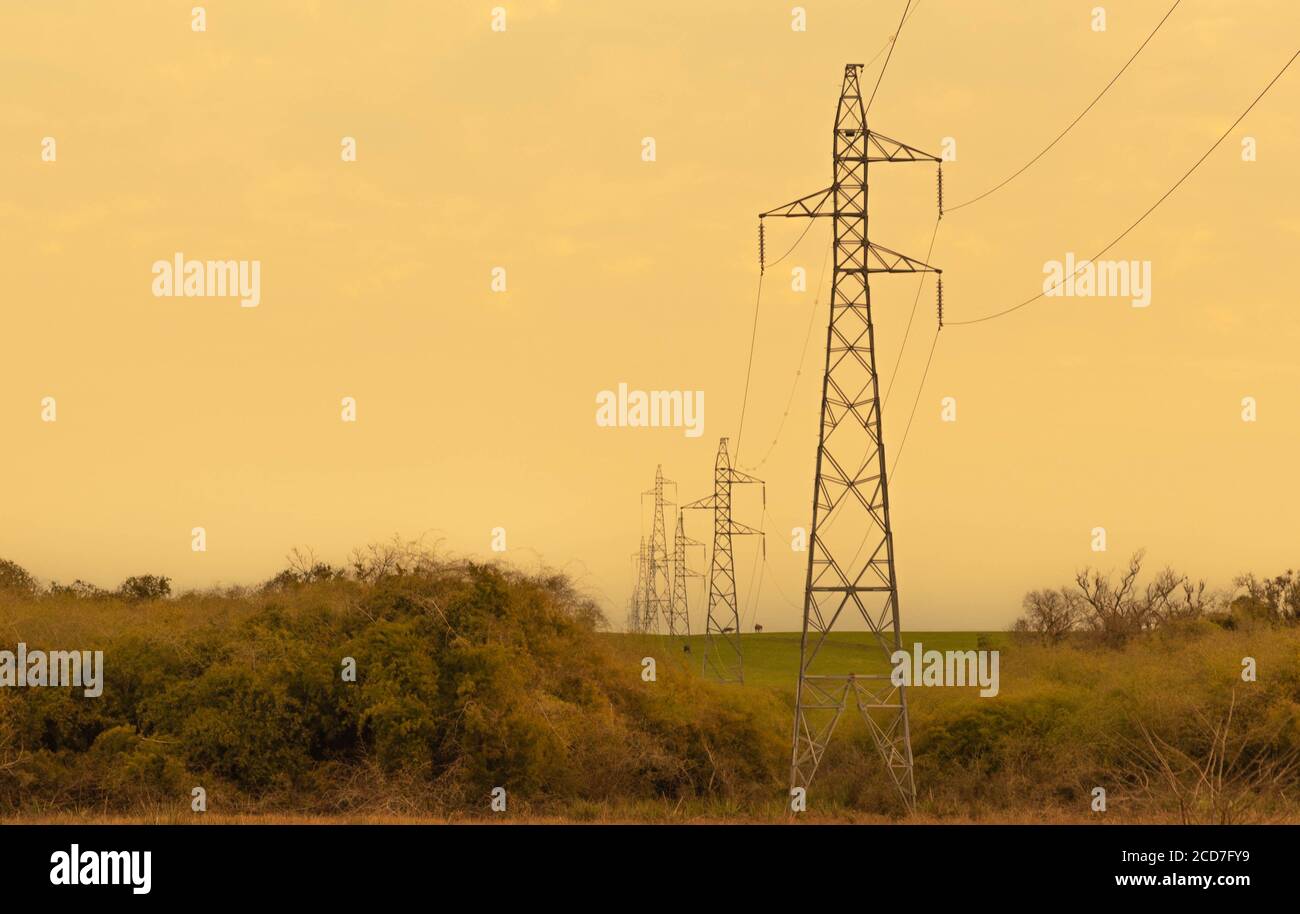 An electrical power grid supported by a group of power towers arranged ...